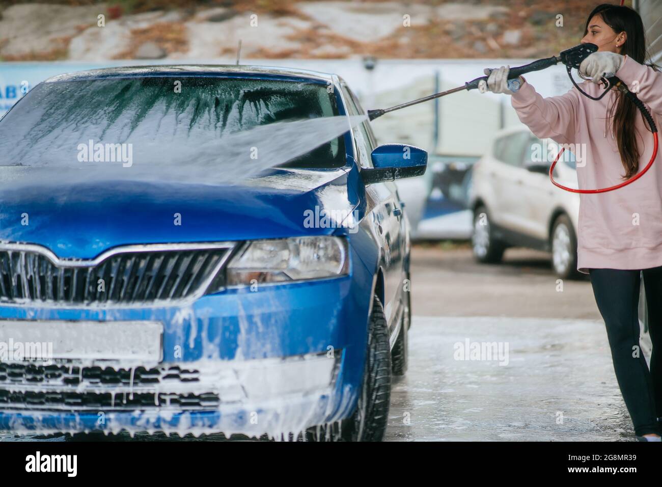 Young woman washing blue car at car wash Stock Photo - Alamy