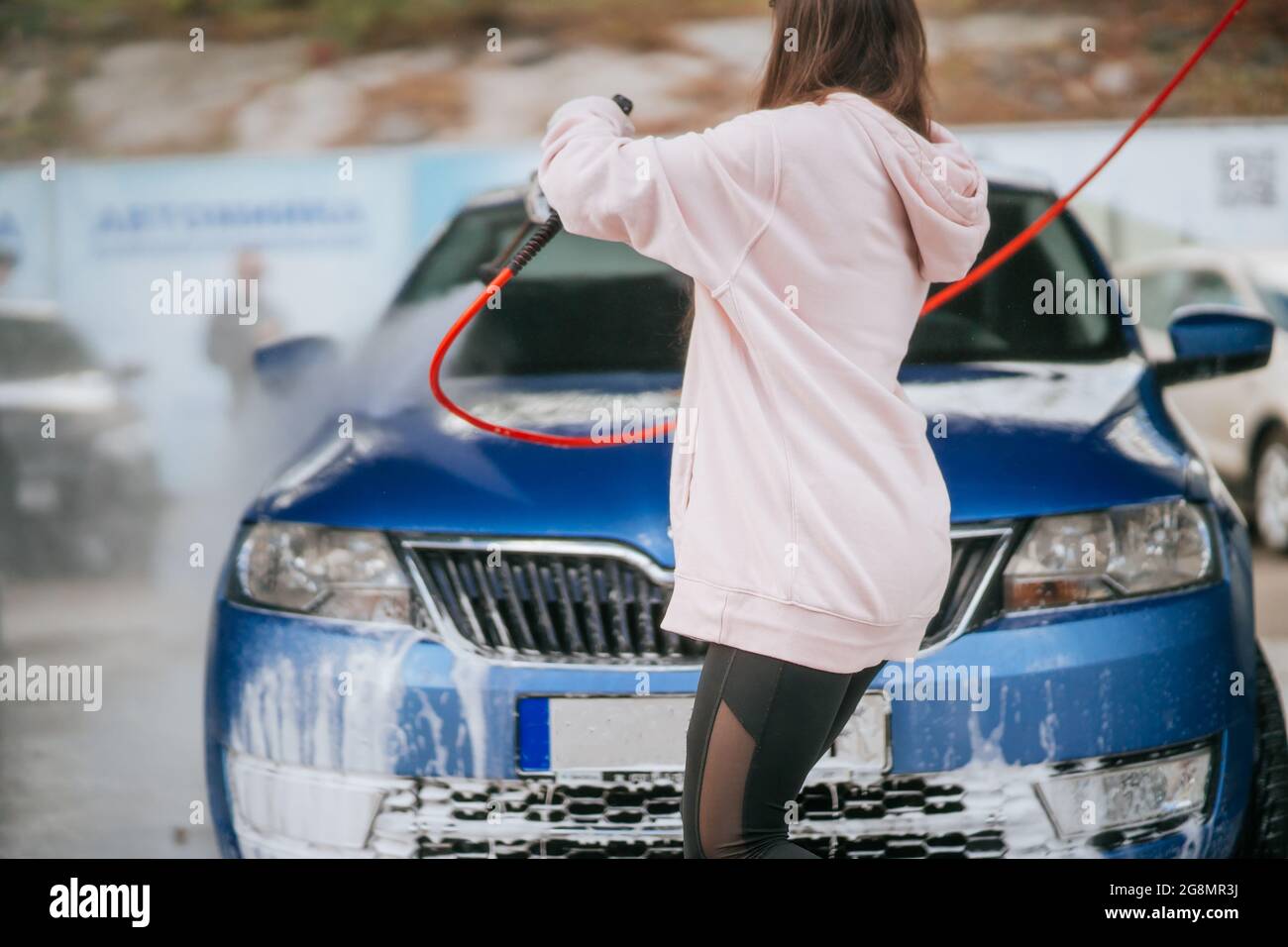Young woman washing blue car at car wash Stock Photo - Alamy