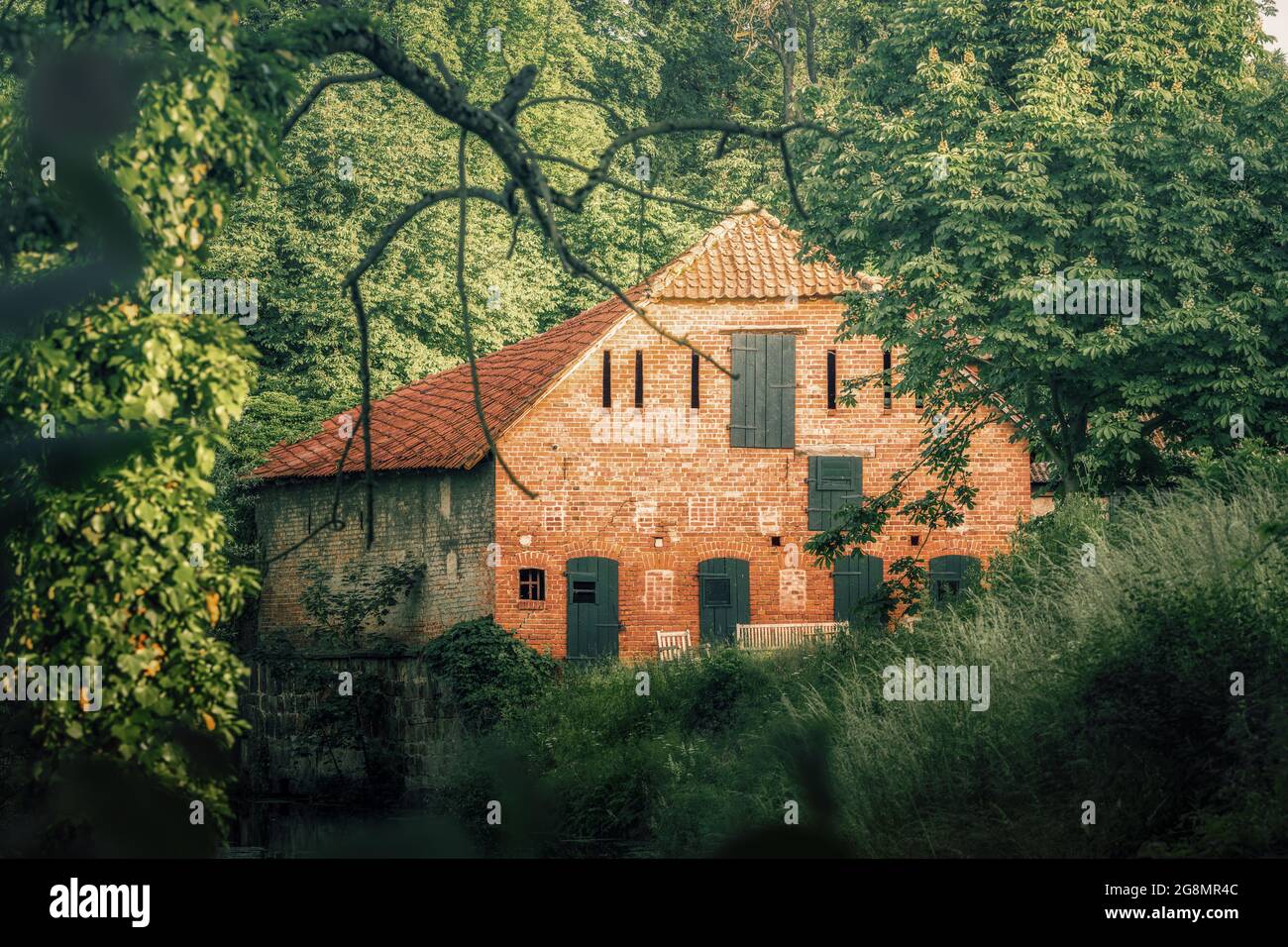 An old idyllic farmhouse in summer on a small river Stock Photo - Alamy
