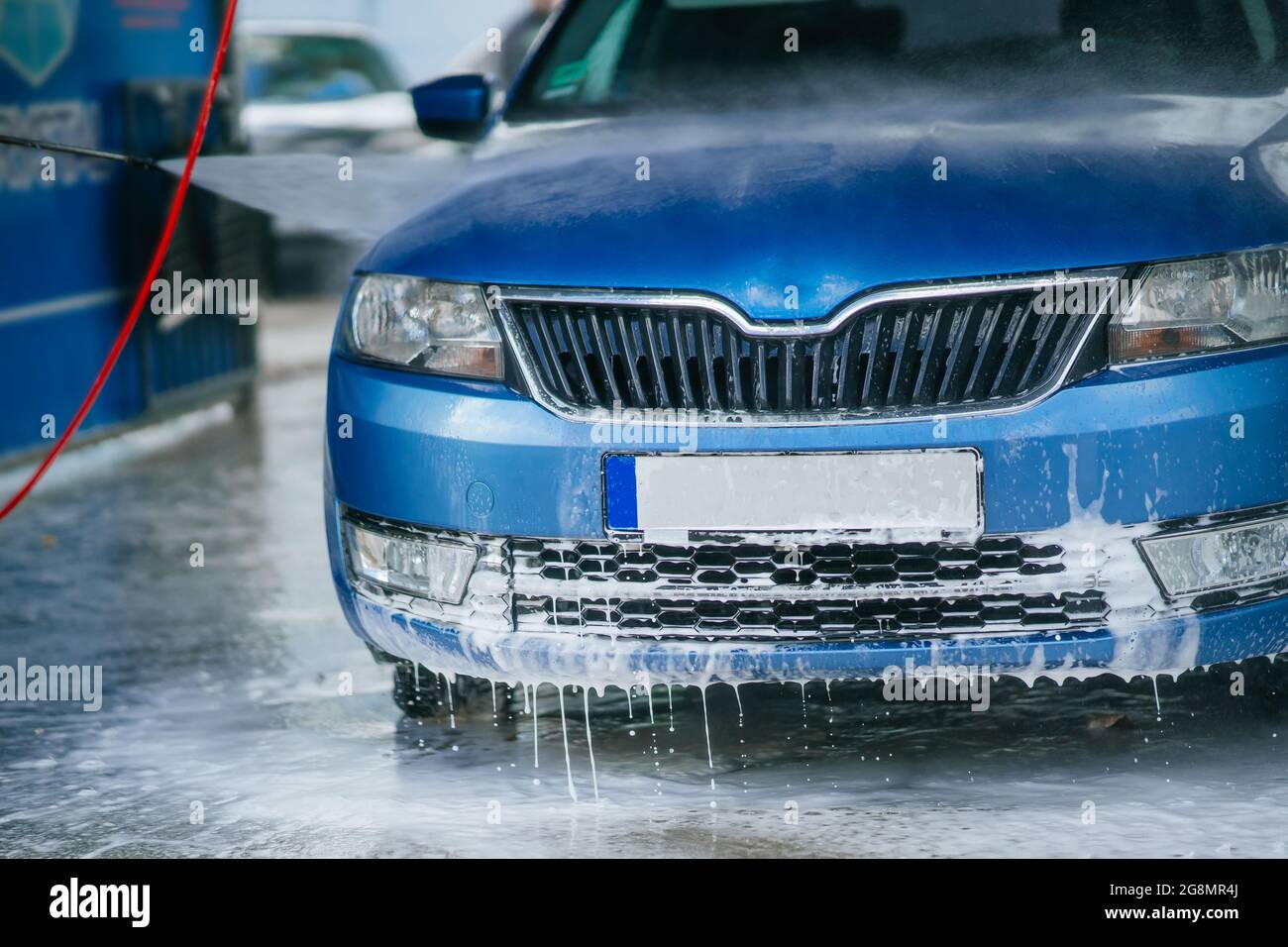 Young woman washing blue car at car wash Stock Photo - Alamy