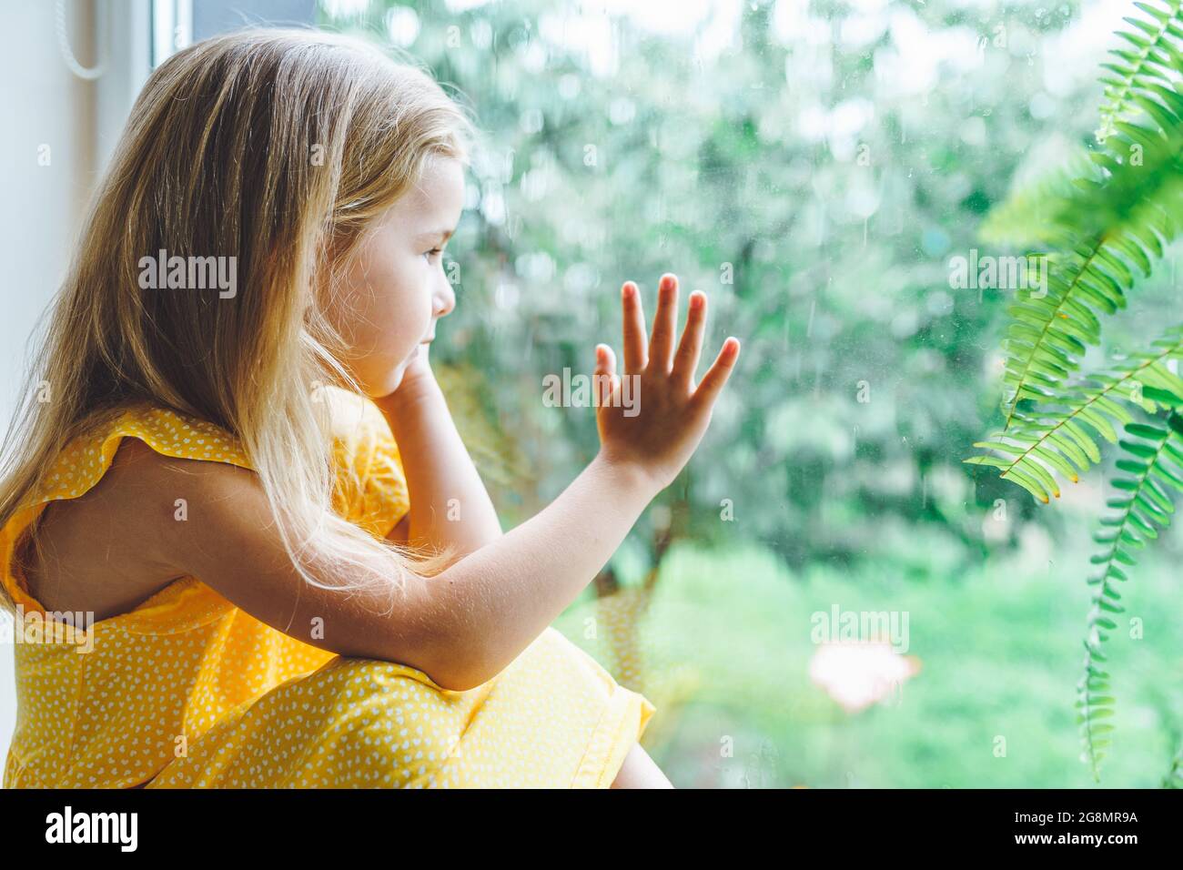 Girl looking out window sad rain hi-res stock photography and images ...
