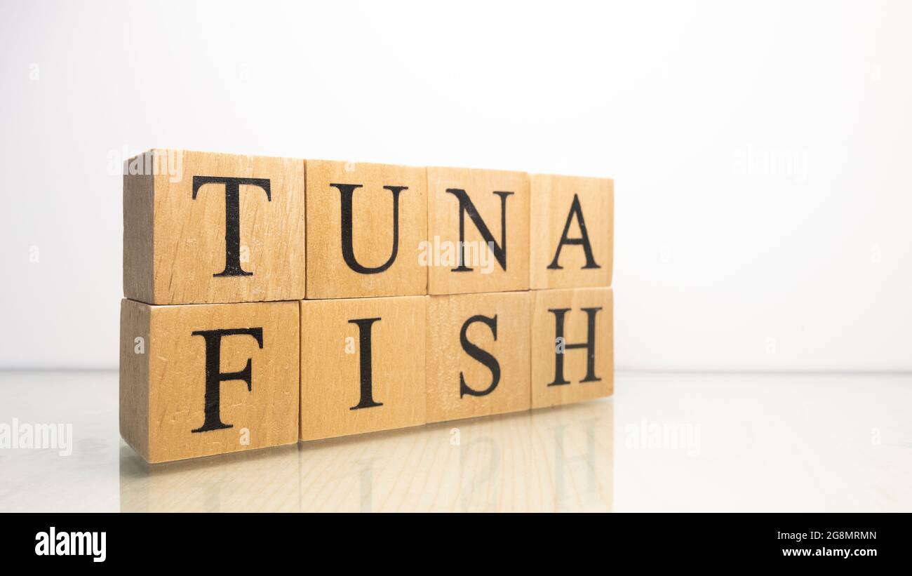 Tuna phrase created from wooden letter cubes. Seafood and food. close ...