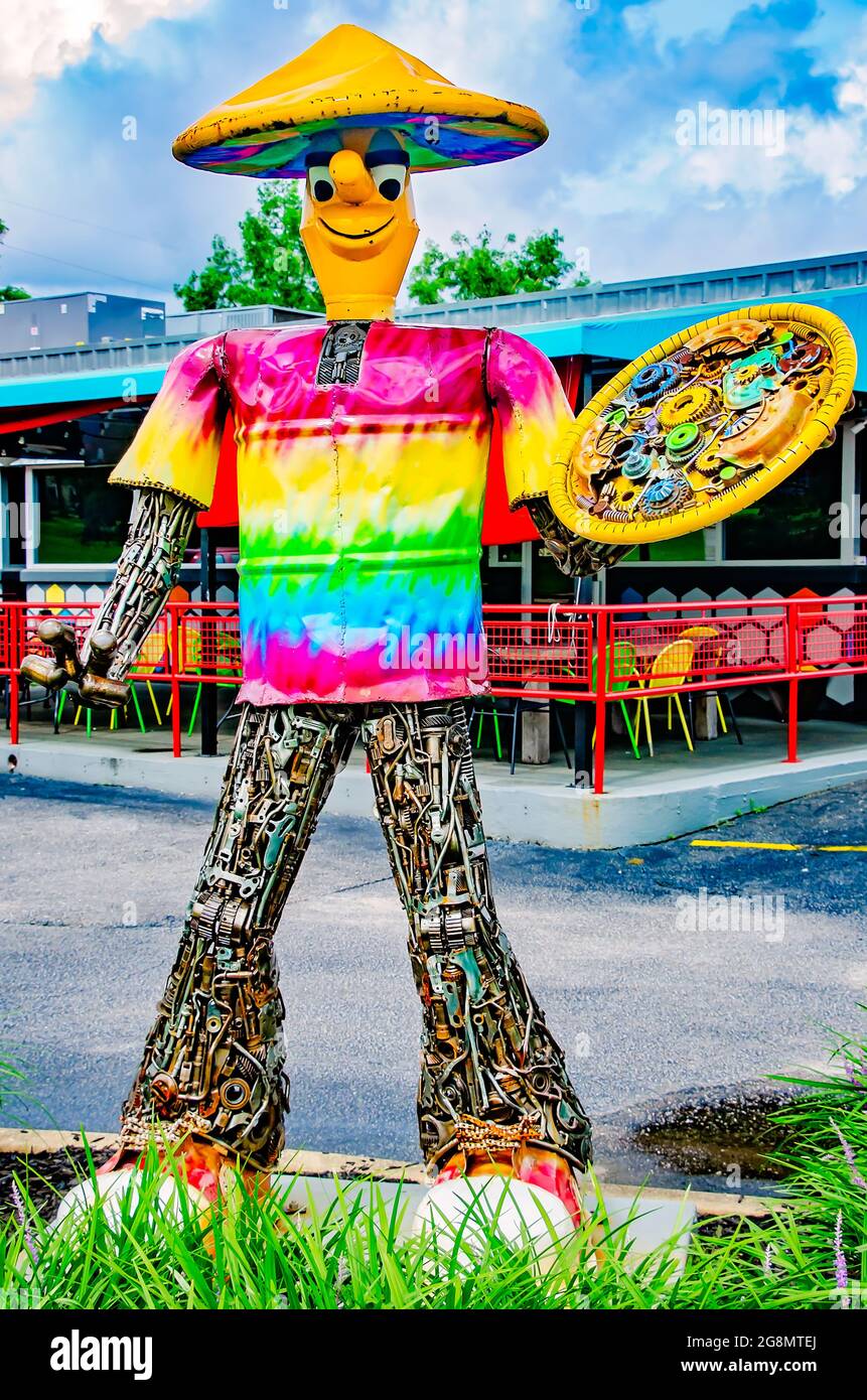 A giant scrap metal man holds a pizza in front of Mellow Mushroom, July ...