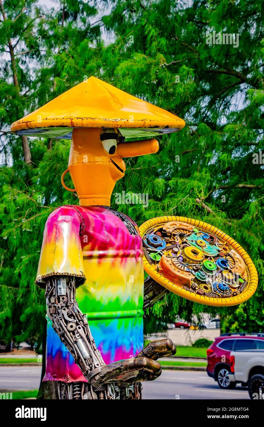 A giant scrap metal man holds a pizza in front of Mellow Mushroom, July ...