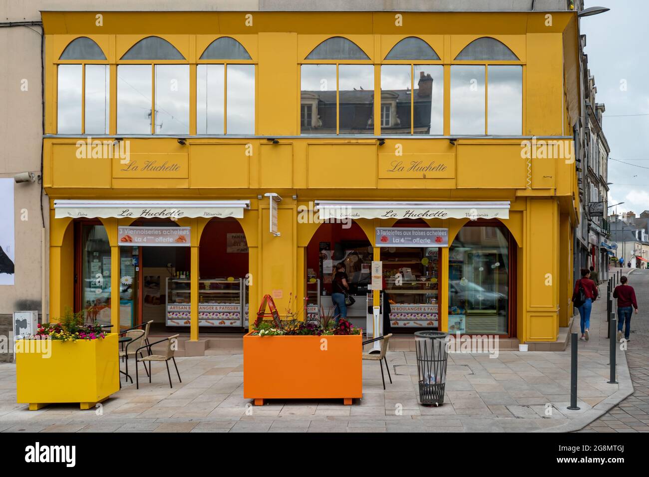 SABLE, FRANCE - Jul 12, 2021: A bright yellow storefront on a busy road ...