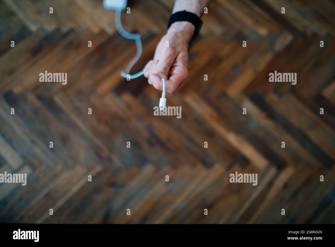 Hand holding charging cable hi-res stock photography and images - Alamy