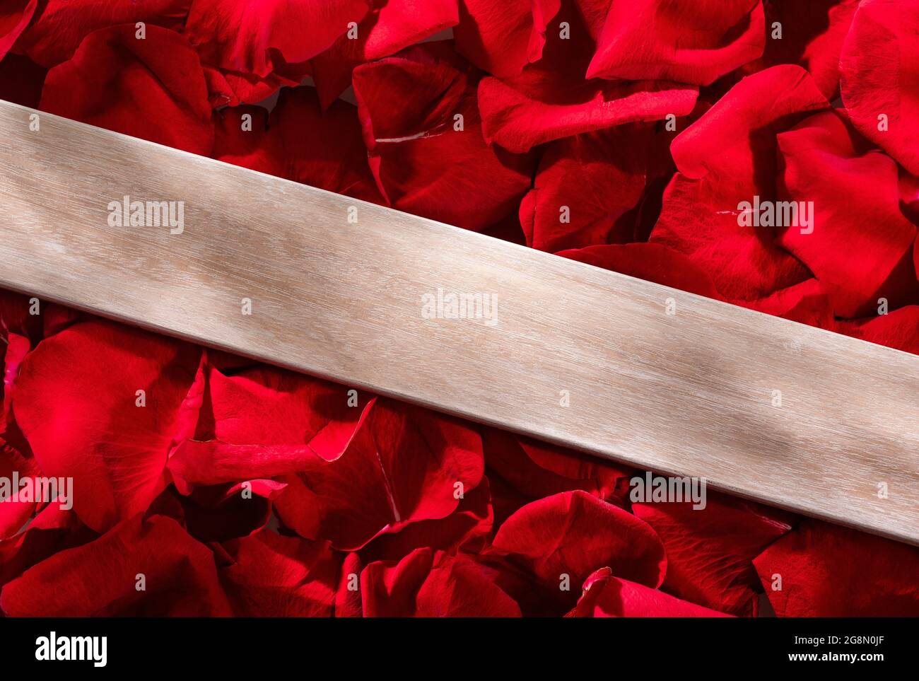 Wooden board on background of red rose petals Stock Photo - Alamy