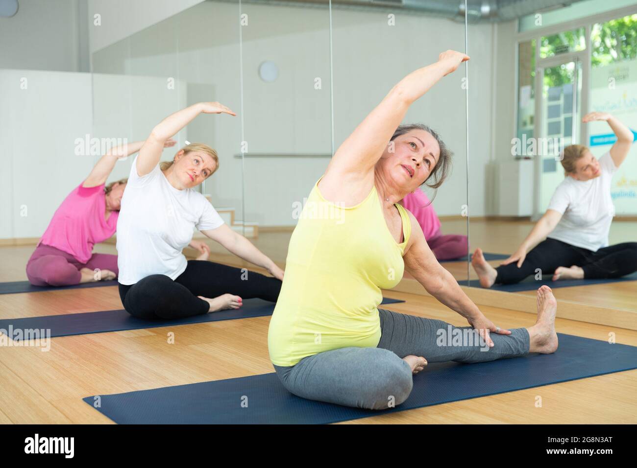 Group yoga modern class - pose matsiendrasana Stock Photo - Alamy