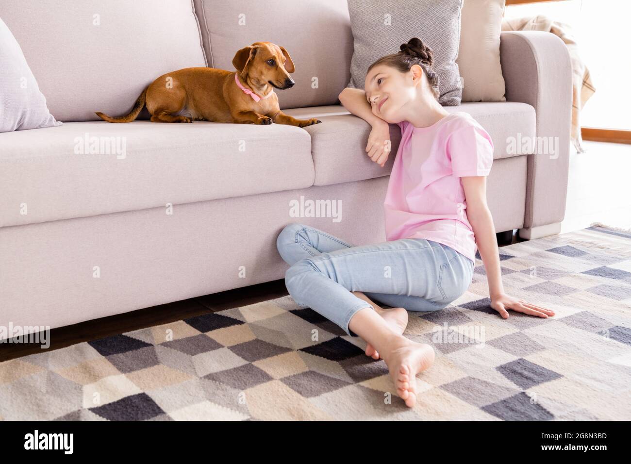 Photo of funny dreamy small schoolgirl dressed pink t-shirt siting ...