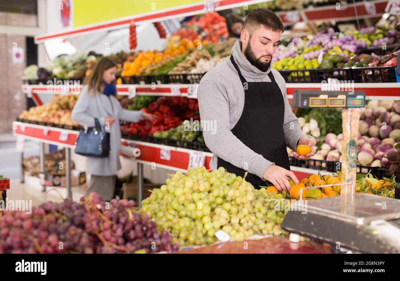 Market worker puts vegetables on the counter Stock Photo - Alamy