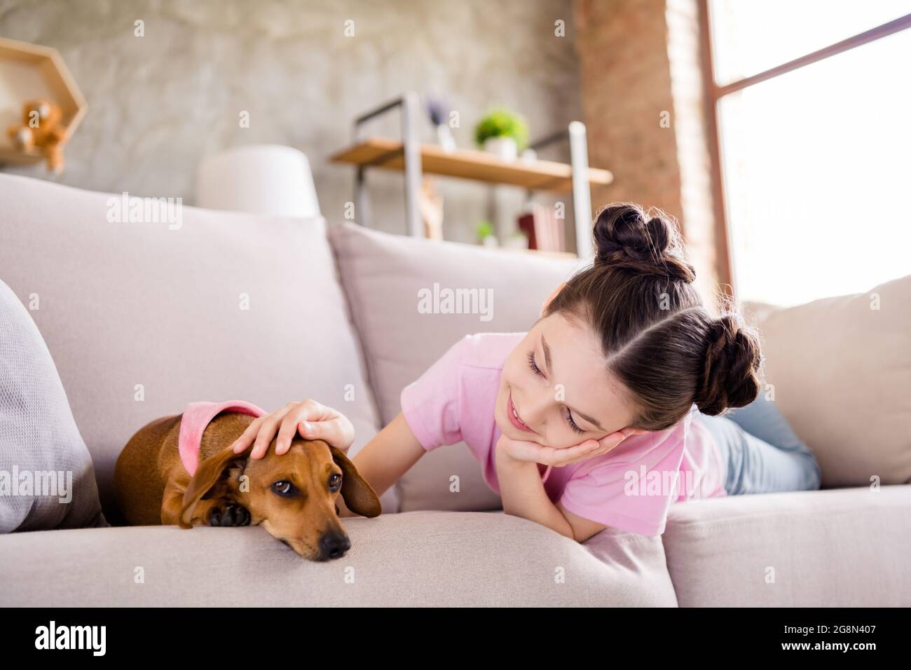 Portrait of attractive cheerful affectionate preteen girl caressing ...