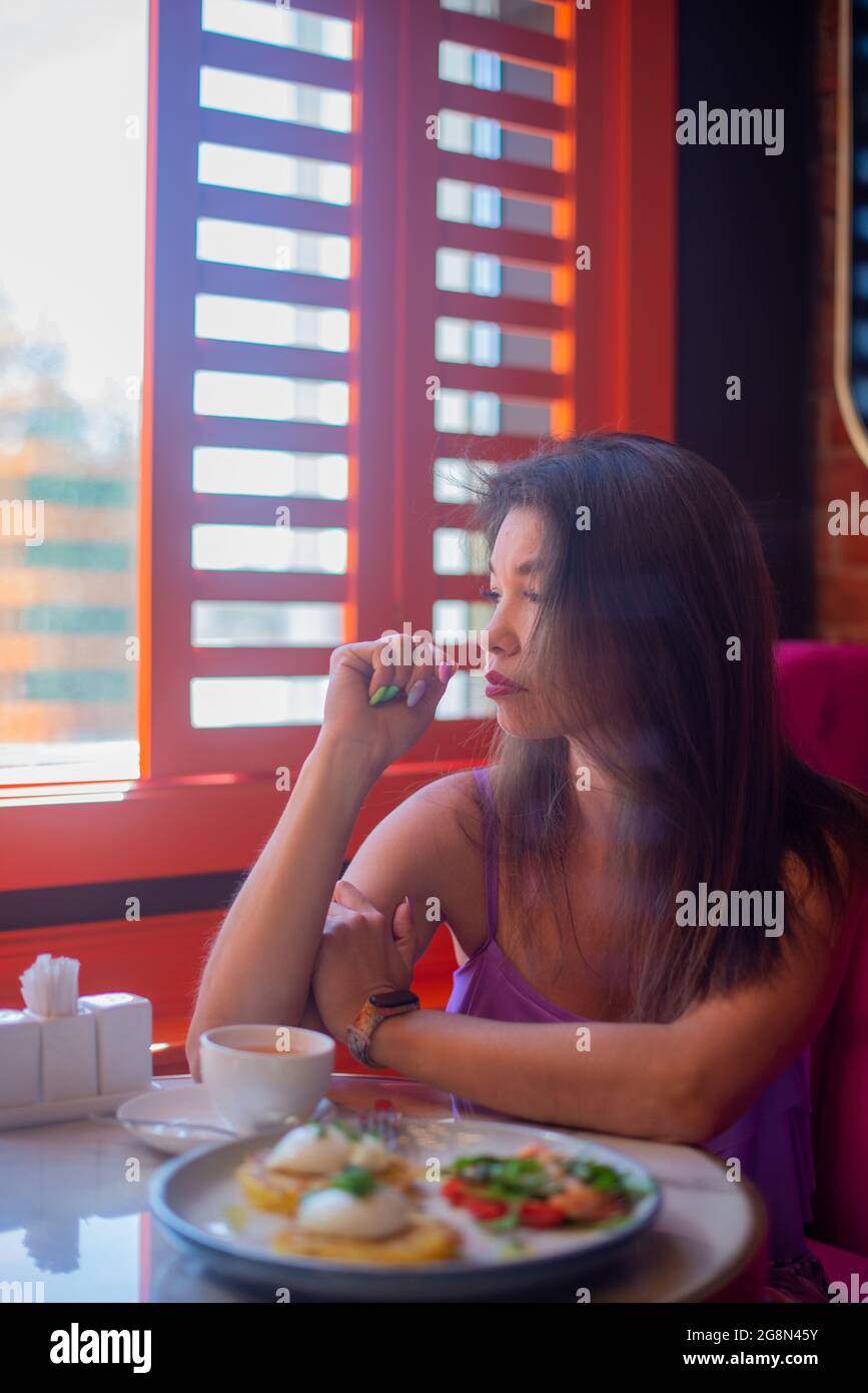 sad girl sitting at a table in a cafe Stock Photo - Alamy