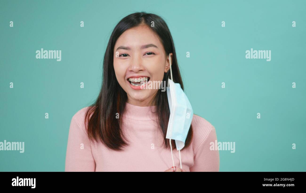 Portrait young Asian happy beautiful woman take off protective face ...