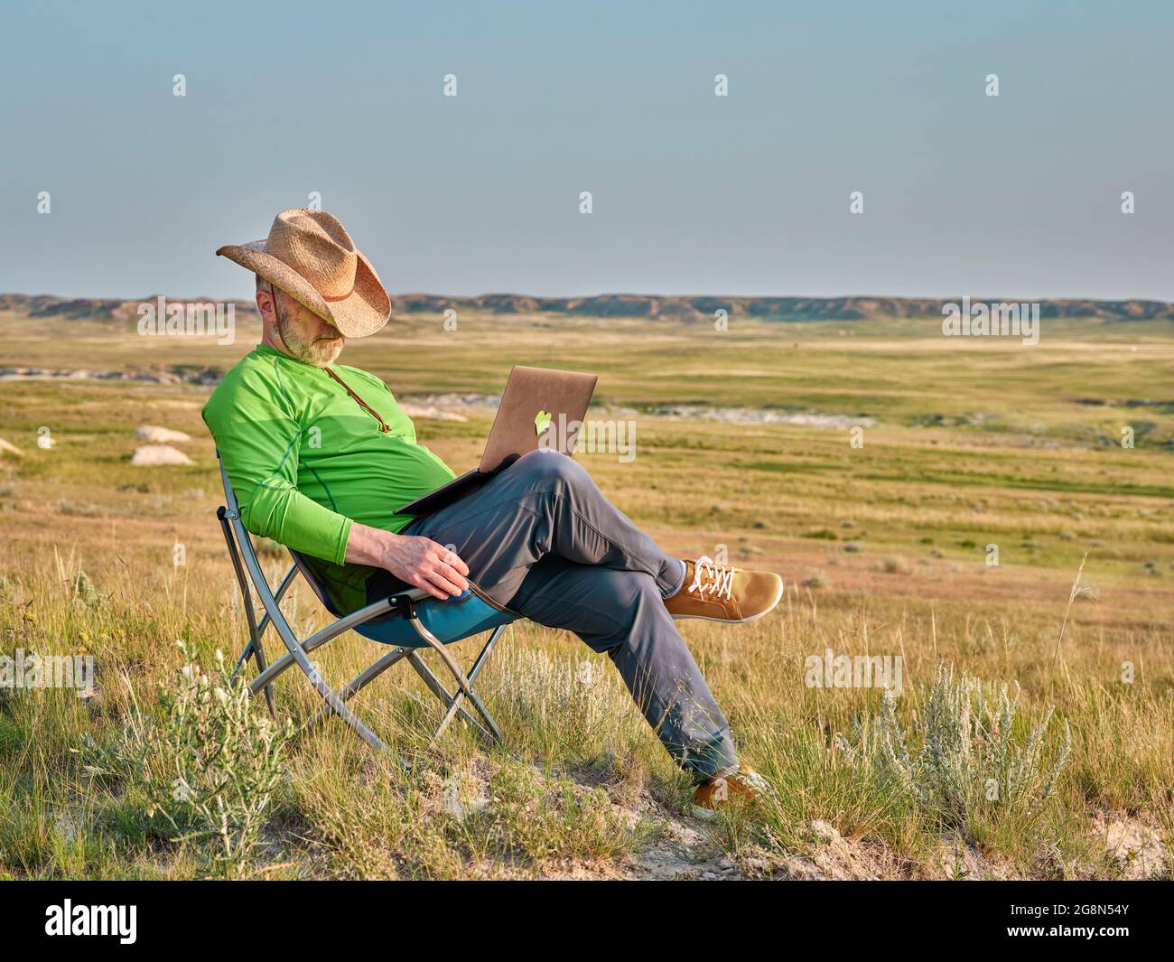 Senior man in cowboy hat is taking a nap in a folding chair while ...