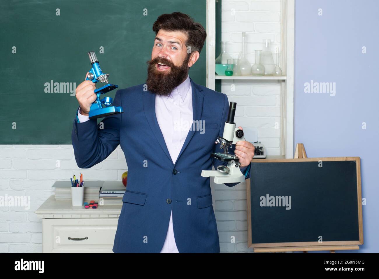 Portrait of happy smiling teacher with microscope, professor, tutor ...