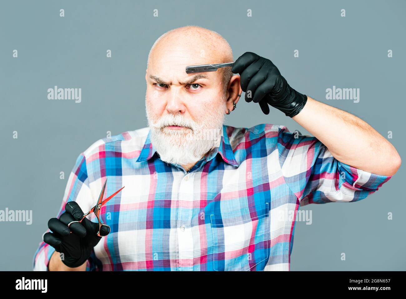 Old hairdresser, mature barber. Portrait of senior barber holding ...