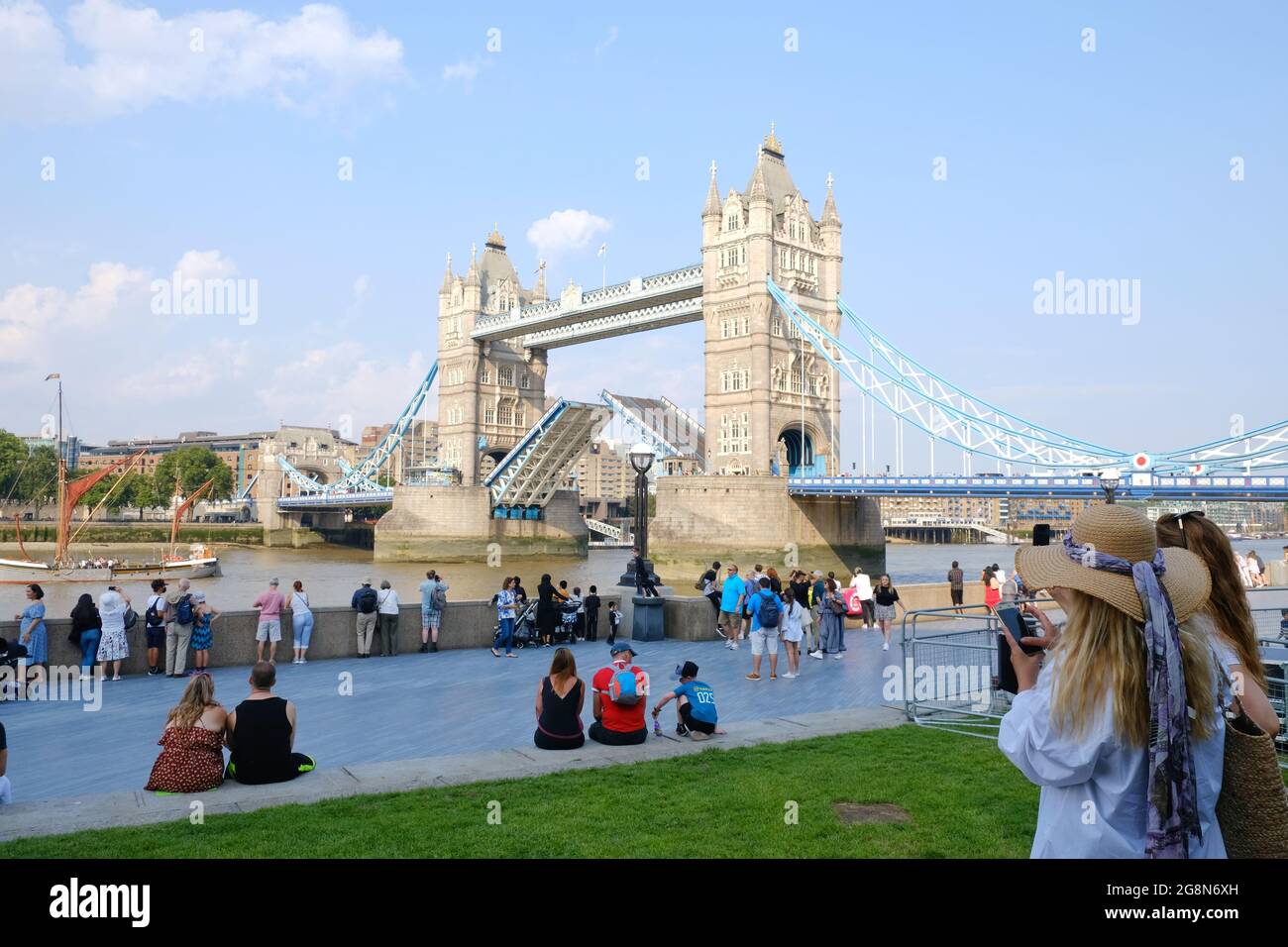 Tower Bridge lifts to allow a vessel to pass underneath, watched on by ...