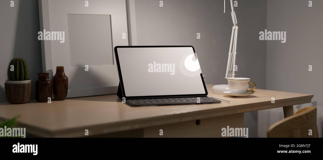 Work space at night with smart tablet and frame in blank screen for ...