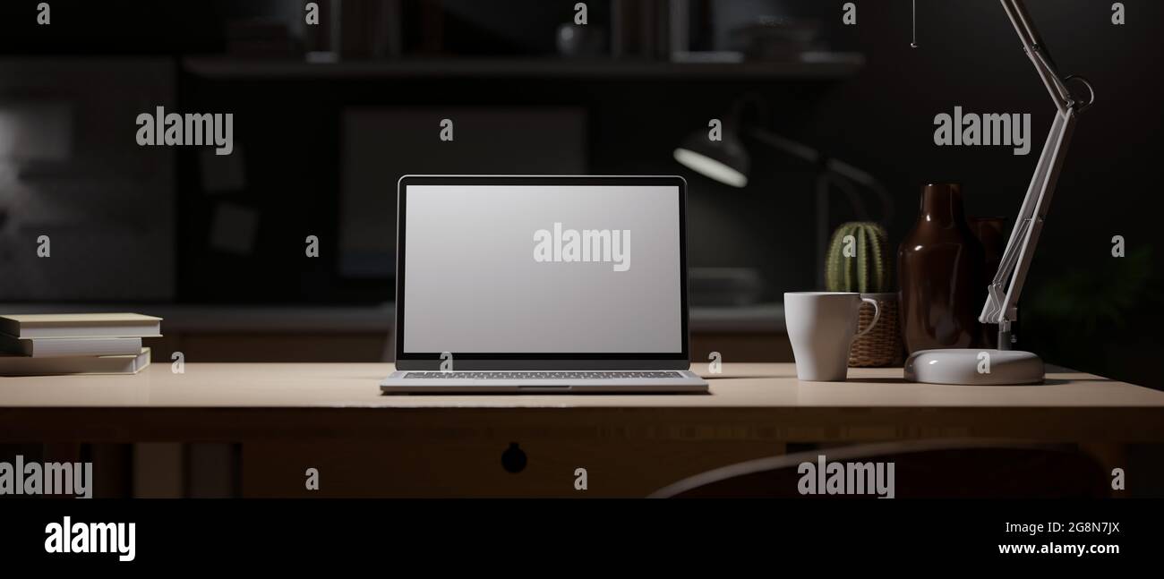 Office at night, dark work space, blank screen laptop mock up on wooden ...