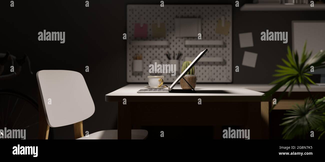 Side view, work space at night with laptop, chair, house plant, coffee ...