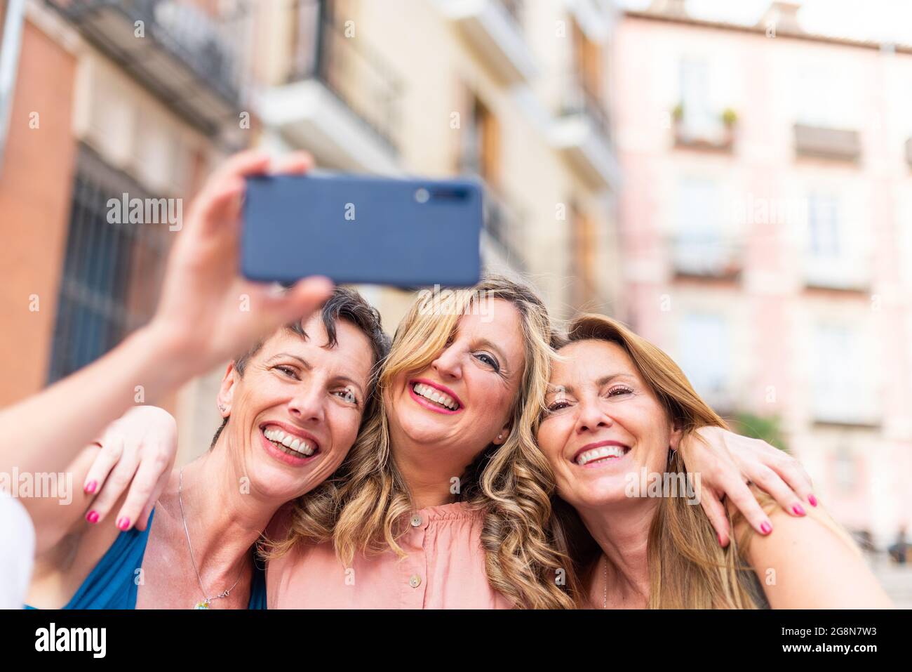 Three middle age female friends hugging together taking a selfie Stock ...
