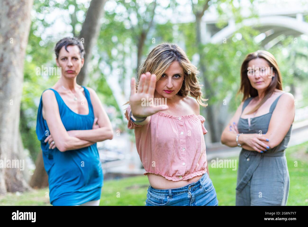 A mature adult woman making the stop gesture with a serious expression ...