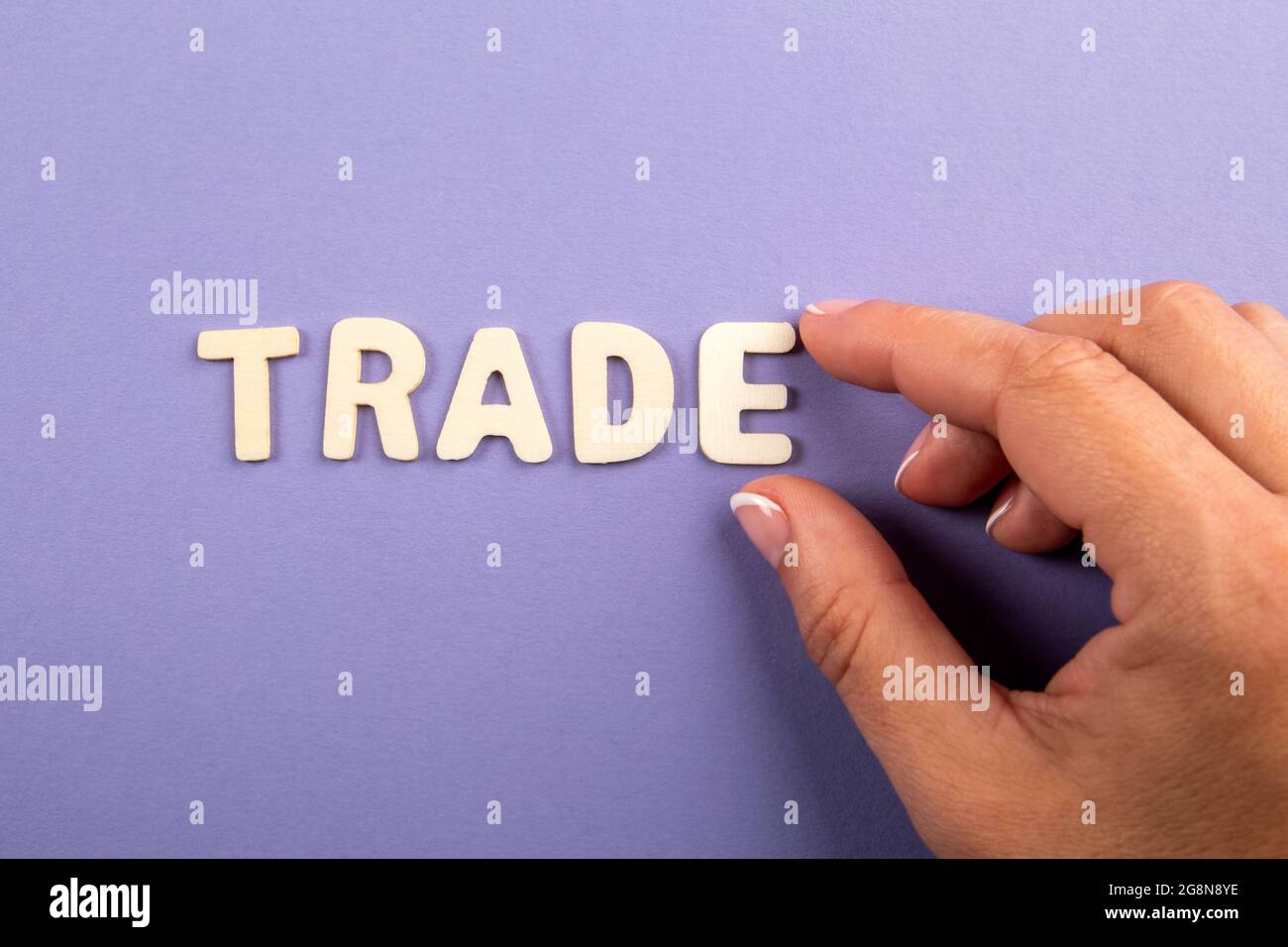 Trade. White letters and a woman's hand on a purple background Stock ...