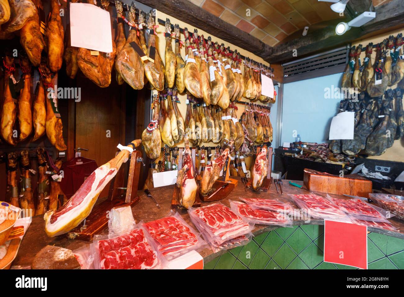 Assortment of traditional Spanish meat shop with dangling legs jamon ...