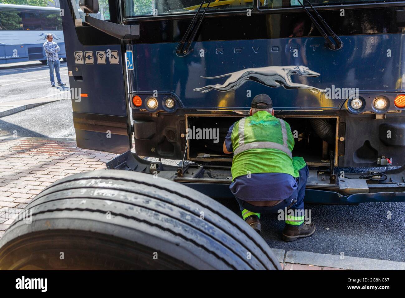 A man pulls a spare tire from a bus so he can replace itPhotos ...