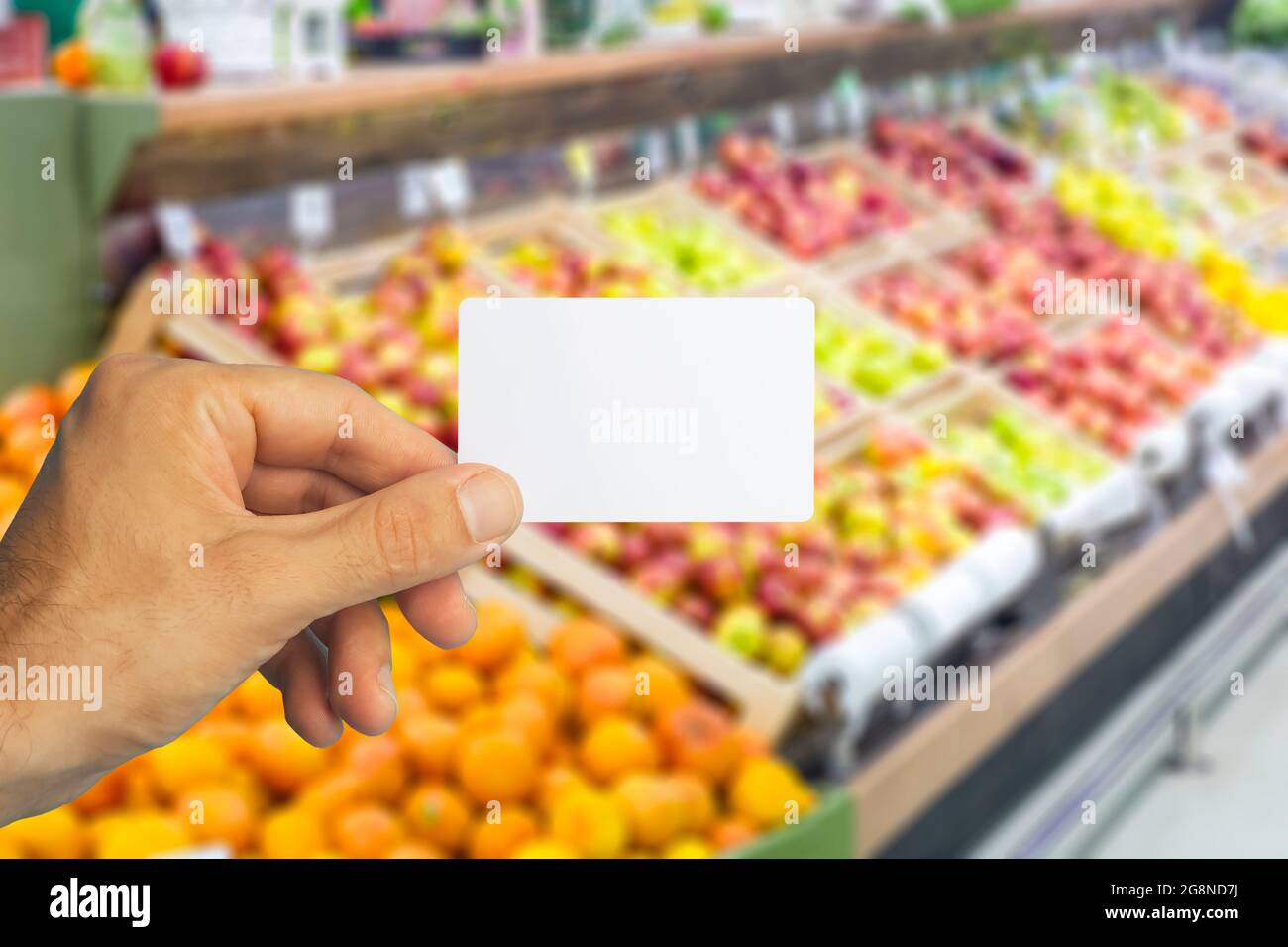 Empty plastic grocery card in hand on supermarket background. Grocery ...
