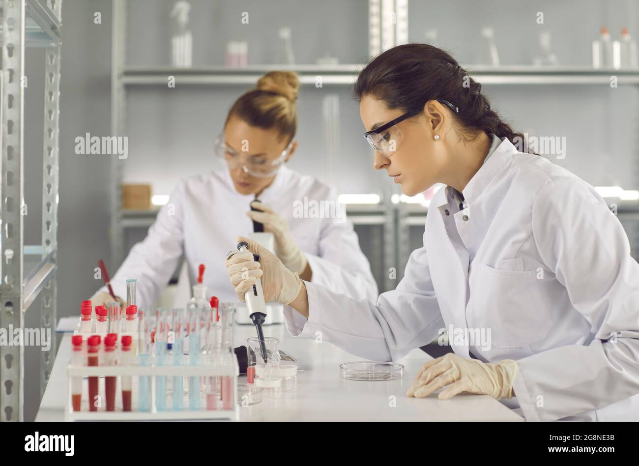 Group of serious female scientists working in a pharma or biotech ...