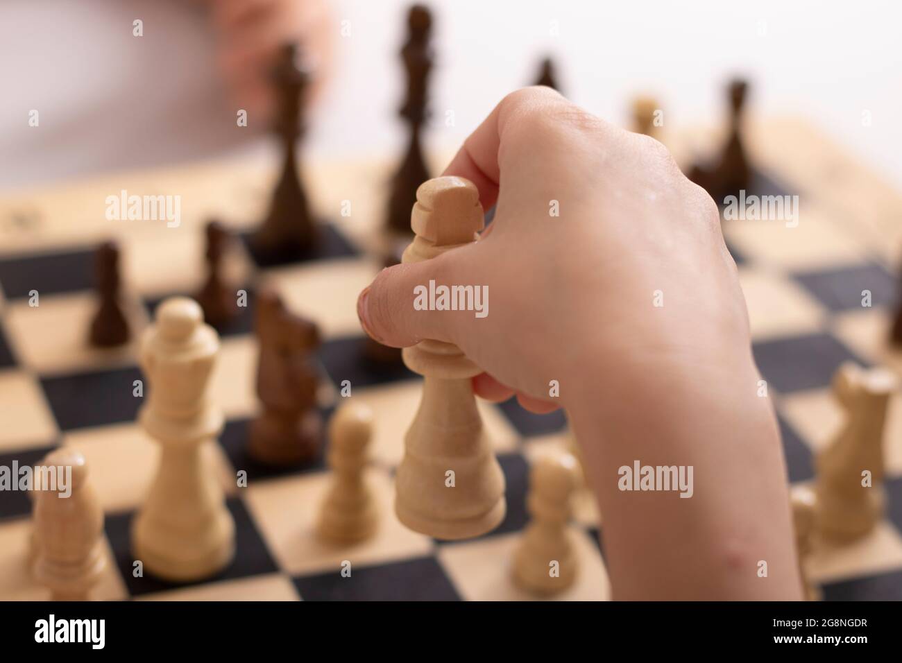 Kids hand holding wooden king chess to make step Stock Photo - Alamy