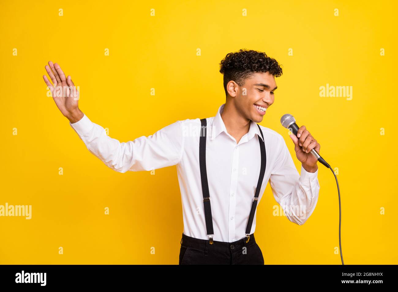 Photo of singer guy hold mic sing have fun wear white shirt suspenders ...