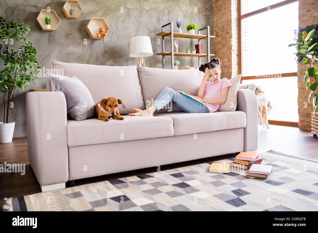 Photo of cute tired schoolgirl dressed pink t-shirt sitting couch doing ...