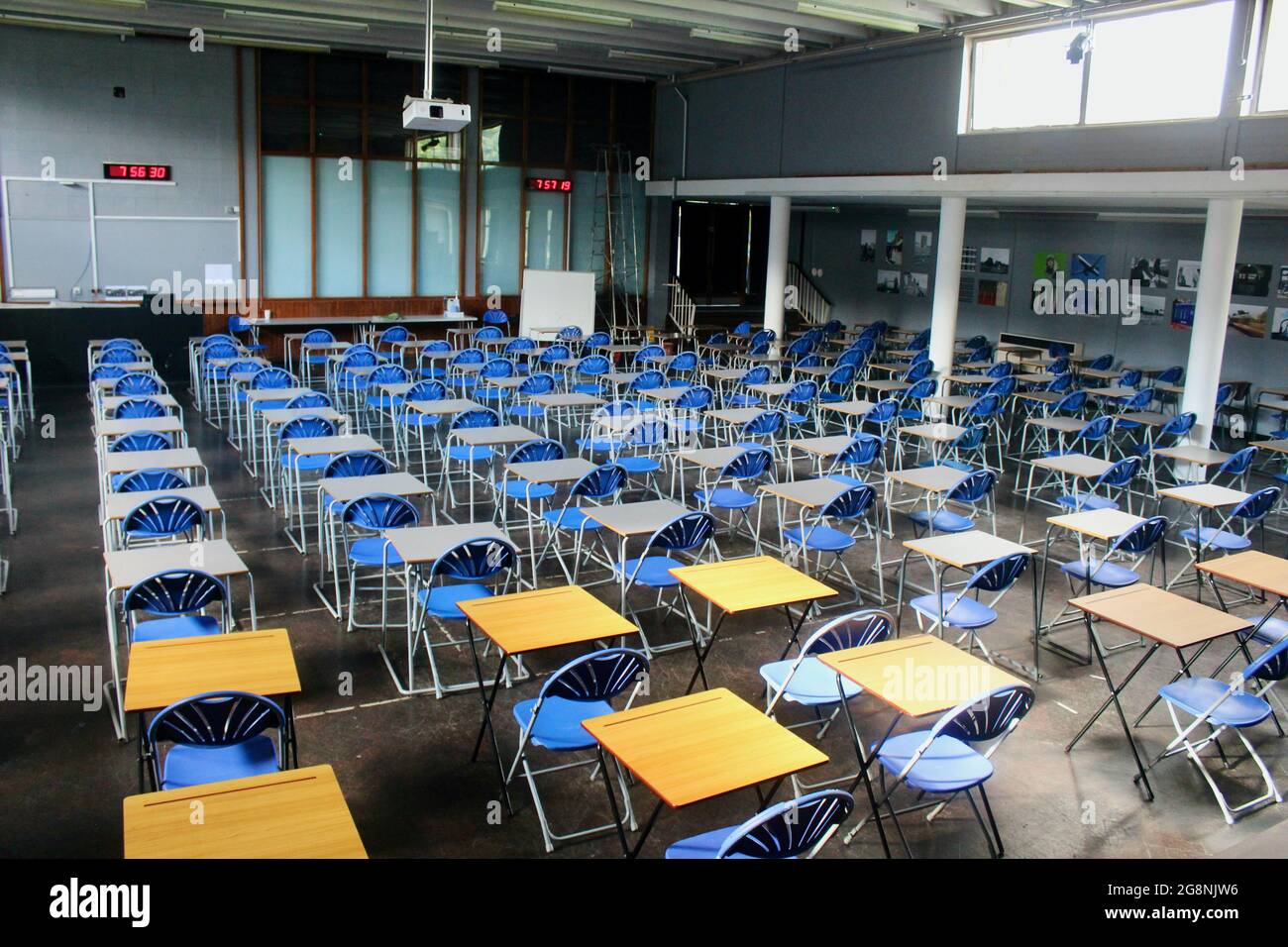 english school hall full of lines of chairs and tables for examinations ...