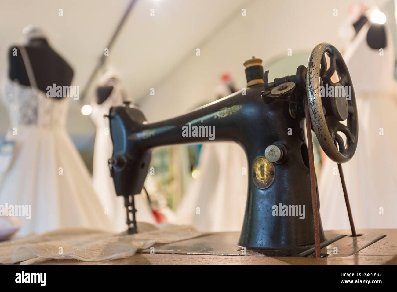 Tailoring detail for bridal dresses with a sewing machine and white ...