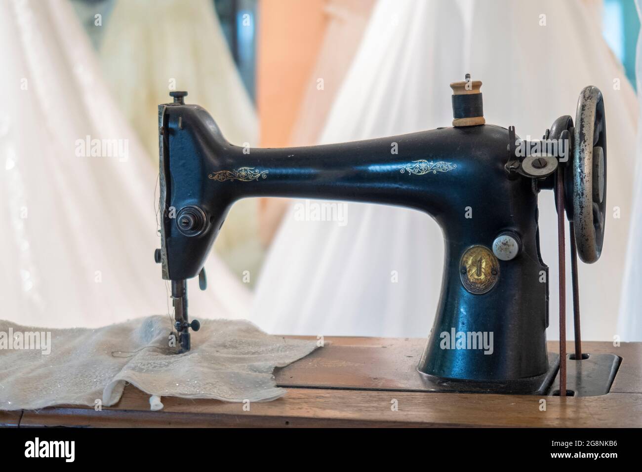 Tailoring detail for bridal dresses with a sewing machine and white ...
