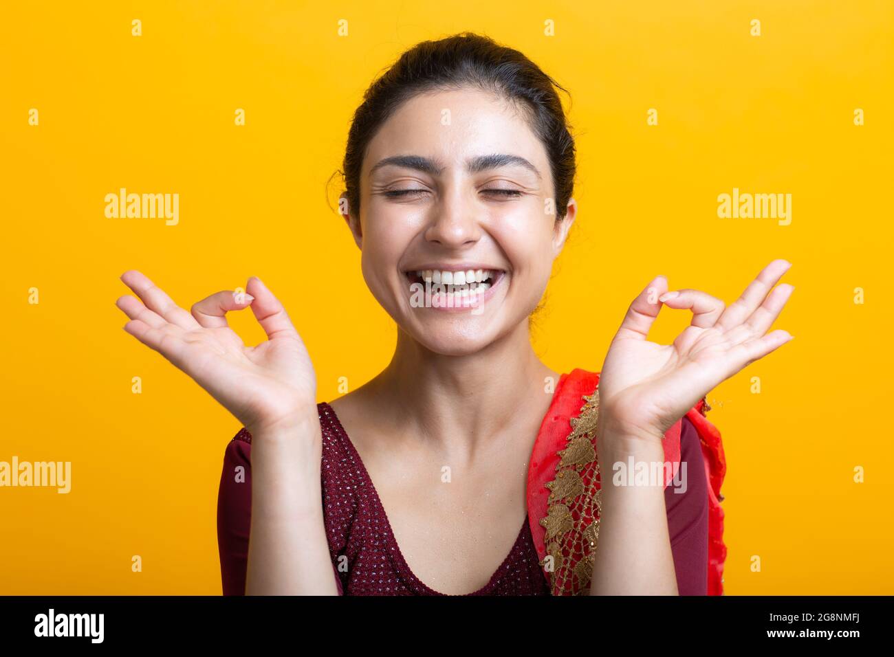 Portrait of young adult indian woman in sari meditating zen like with ...