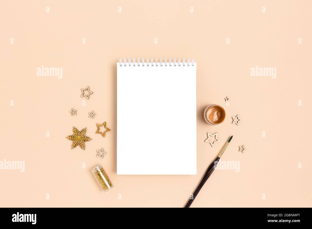 Empty notepad mockup with wooden New Years decoration, golden paint and ...