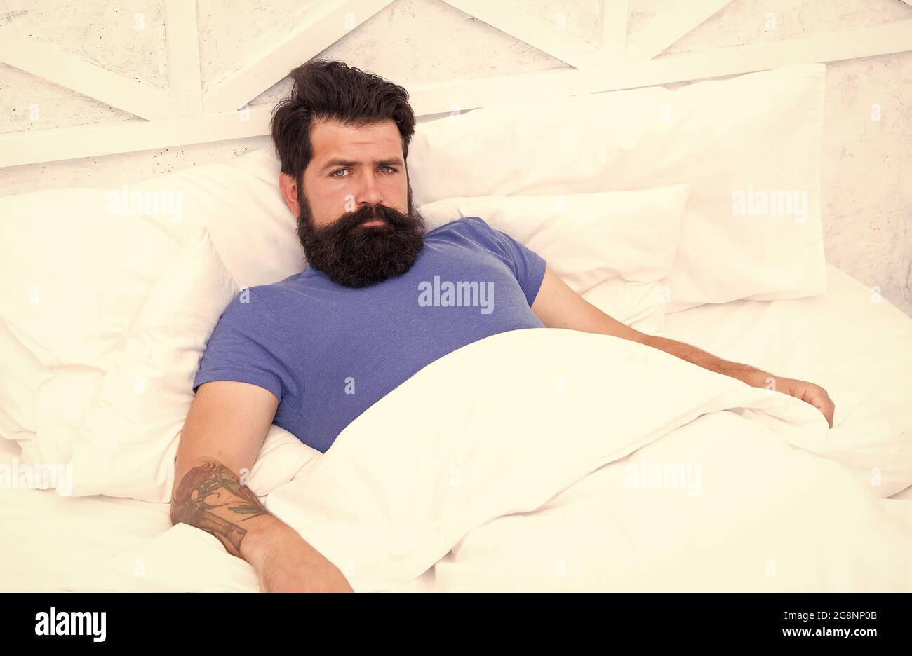 sad and tired bachelor man with beard relax in bad after hangover, male ...