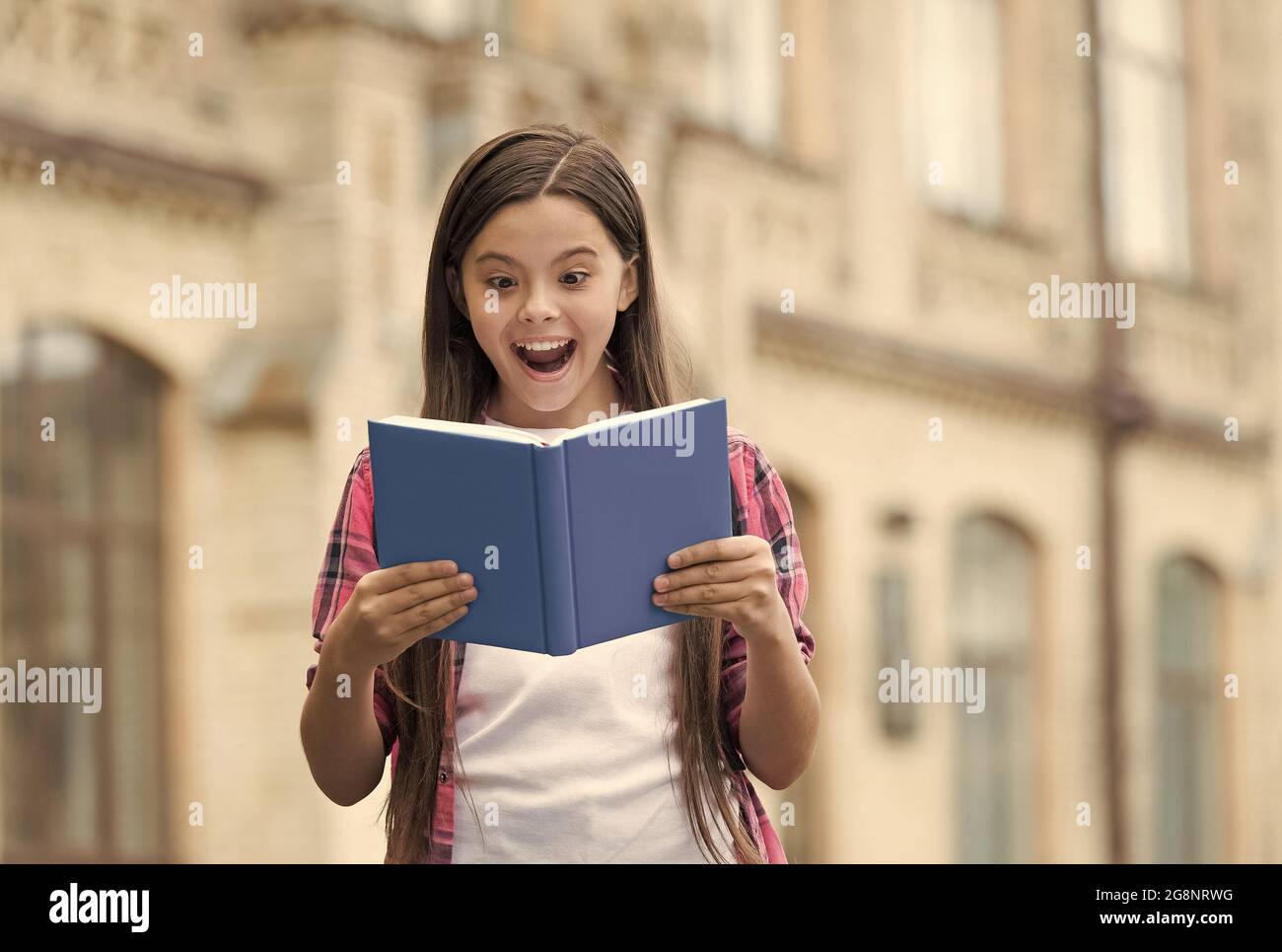 Discover something new. Happy child read book outdoors. Excited ...