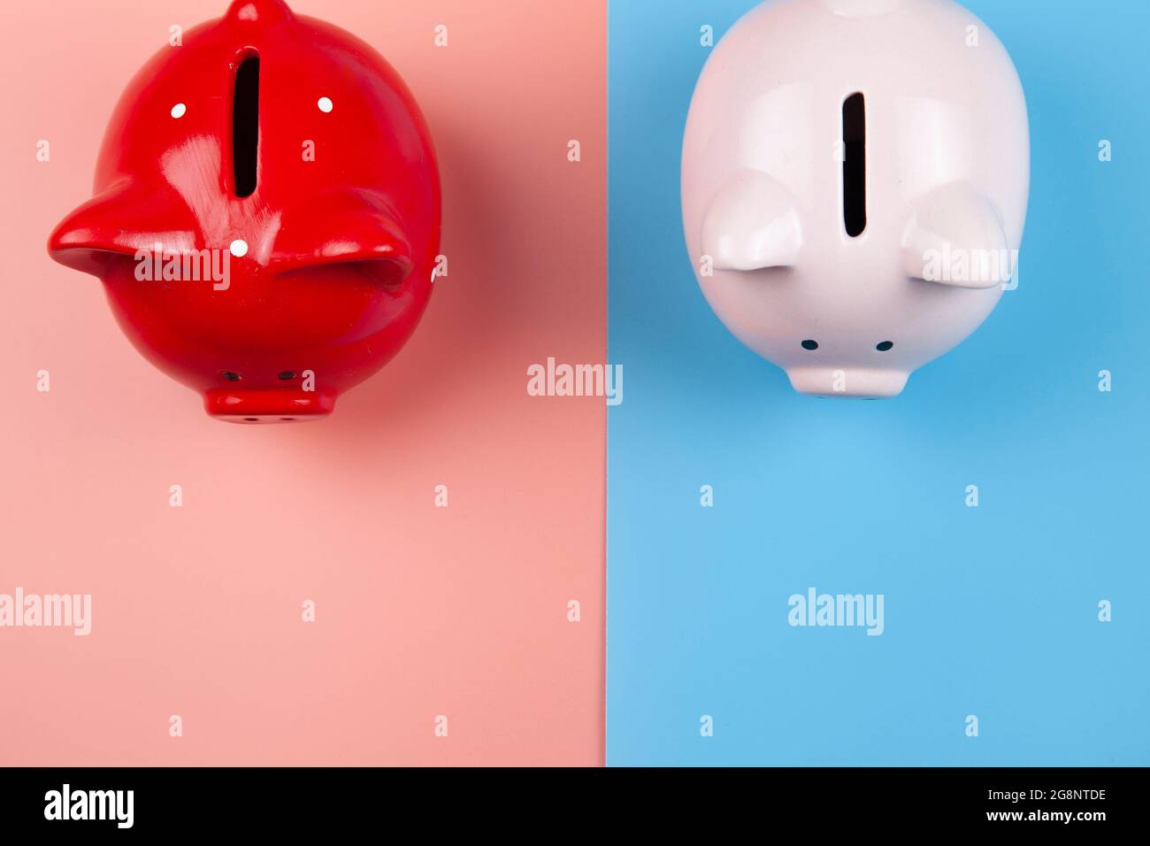 Two pig piggy bank on a pink and blue background Stock Photo - Alamy