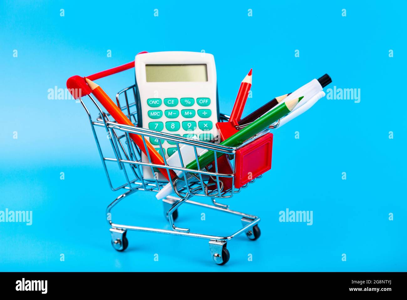 Stationery and shopping cart on a blue background. Shopping for school ...