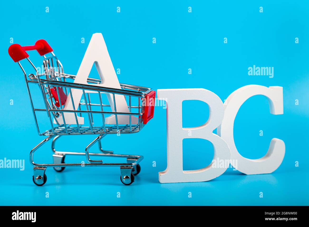 ABC letters and shopping cart on a blue background. Shopping for school ...