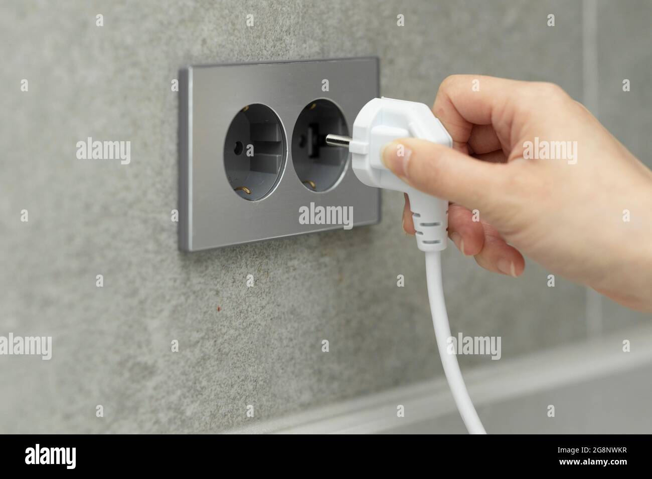 hand plugging out cord from outlet Stock Photo - Alamy