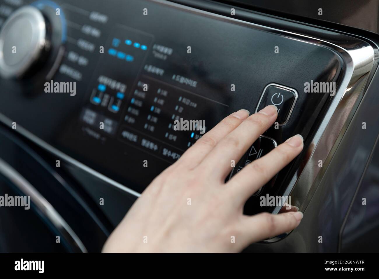 Hand pressing the washing machine power switch Stock Photo - Alamy