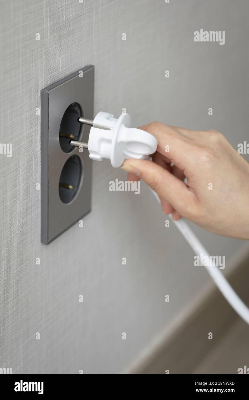 unplugging power socket, outlet Stock Photo - Alamy
