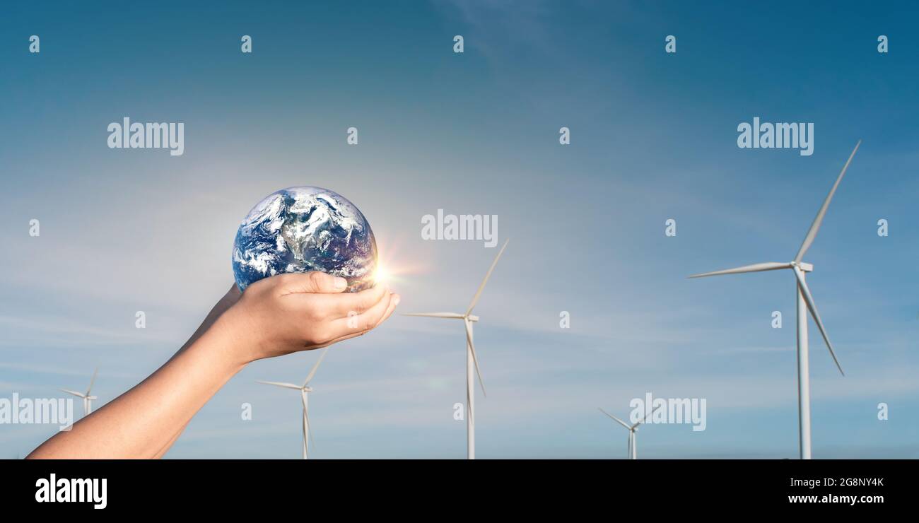 Hands holding Globe, Earth on wind turbine field background. Concept of ...