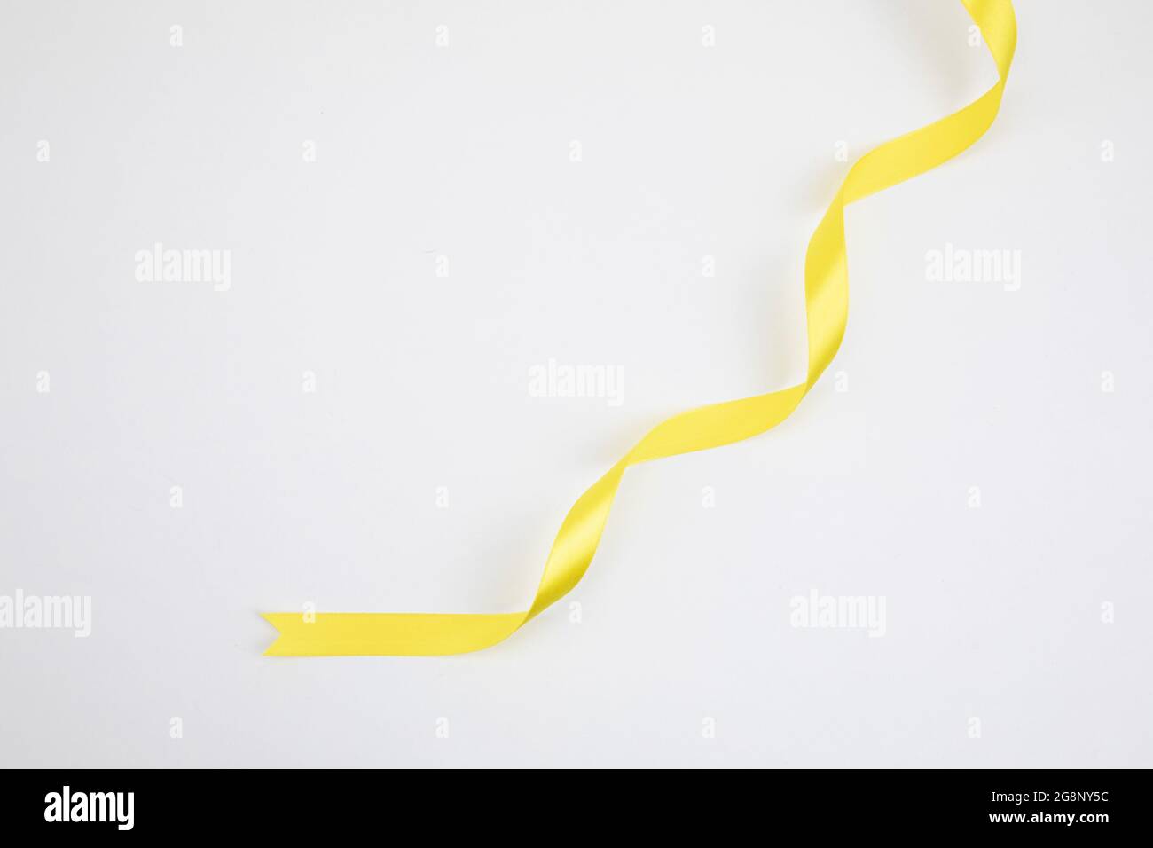 long yellow ribbon, white background Stock Photo - Alamy