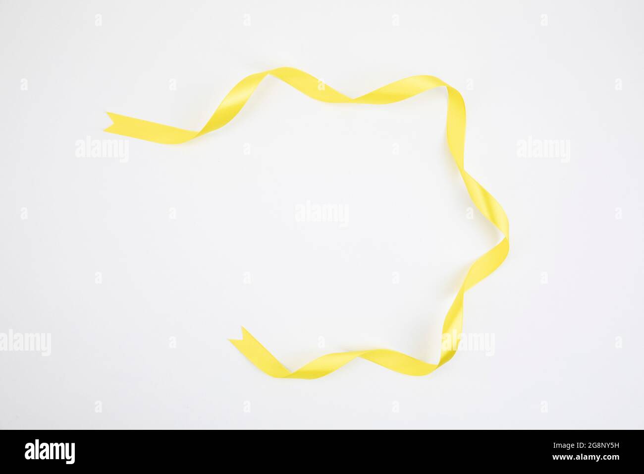 long yellow ribbon, white background Stock Photo - Alamy